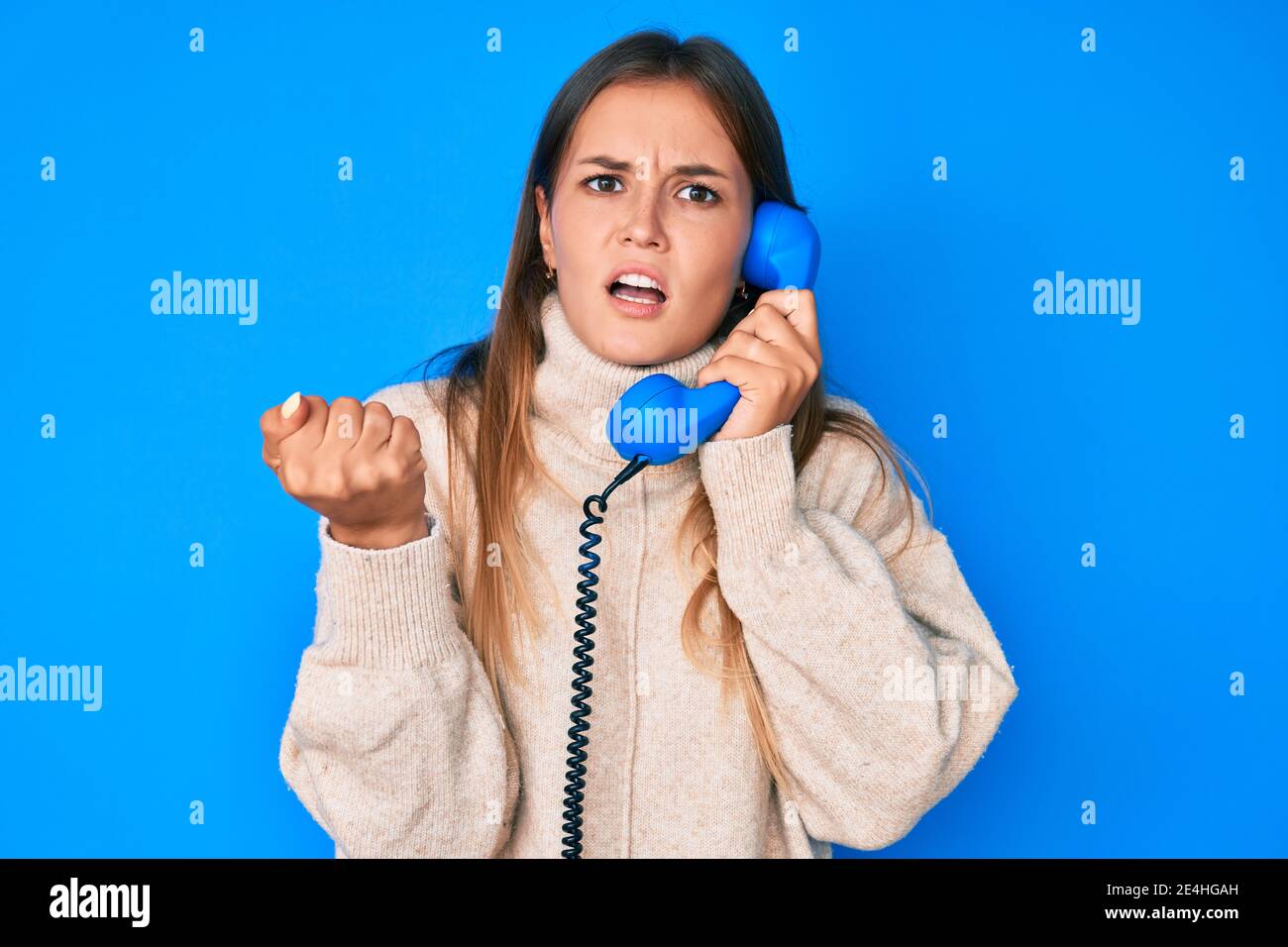 Beautiful caucasian woman speaking on vintage telephone annoyed and ...