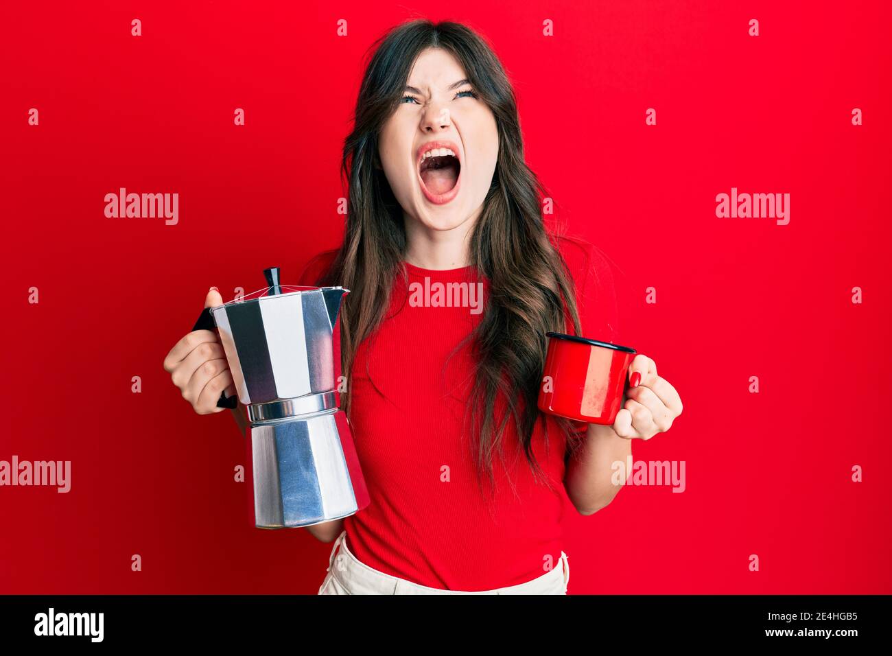 Young beautiful caucasian girl drinking italian coffee angry and mad ...