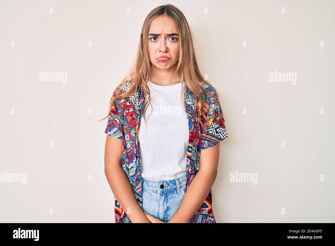 Young beautiful blonde woman wearing modern clothes depressed and worry ...