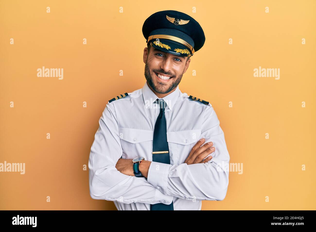 Handsome hispanic man wearing airplane pilot uniform happy face smiling ...