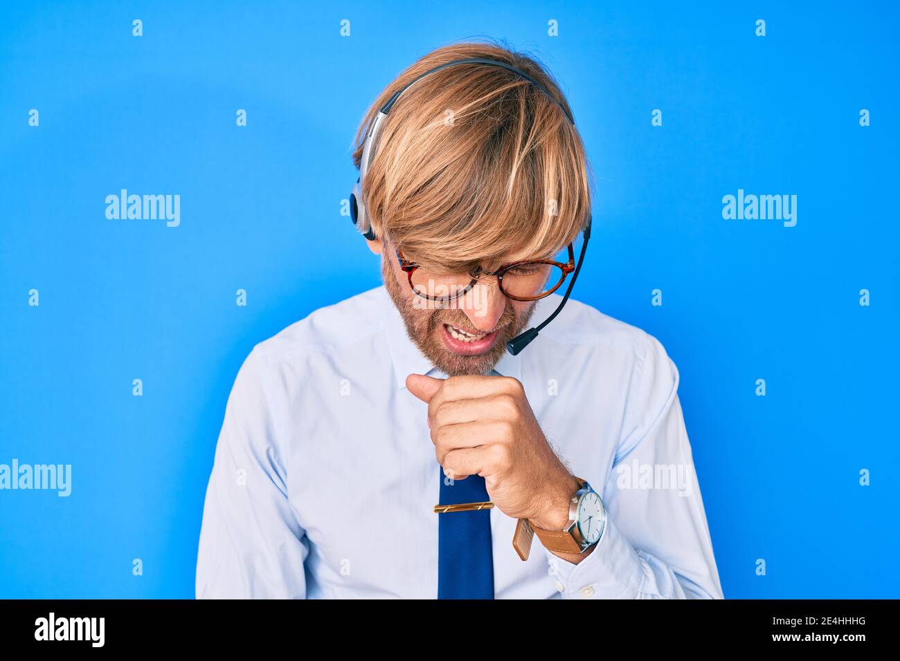 Young blond man wearing call center agent headset feeling unwell and ...