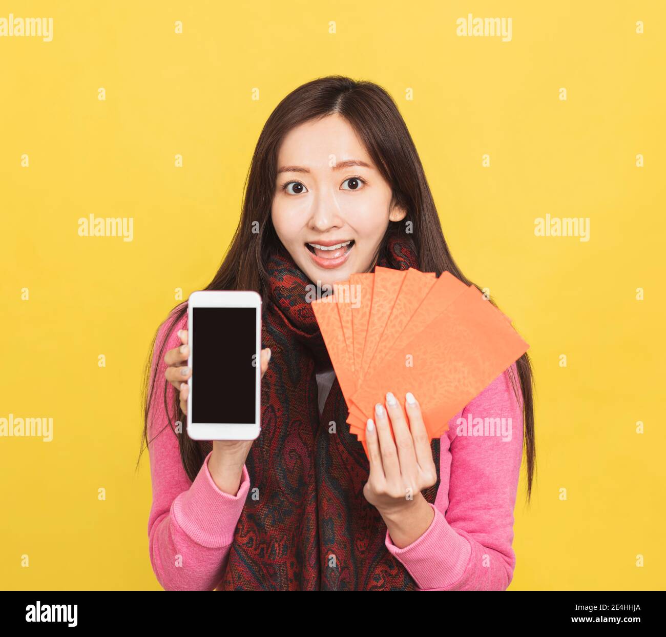 asian woman showing red envelpoe and mobile phone screen, celebrating ...