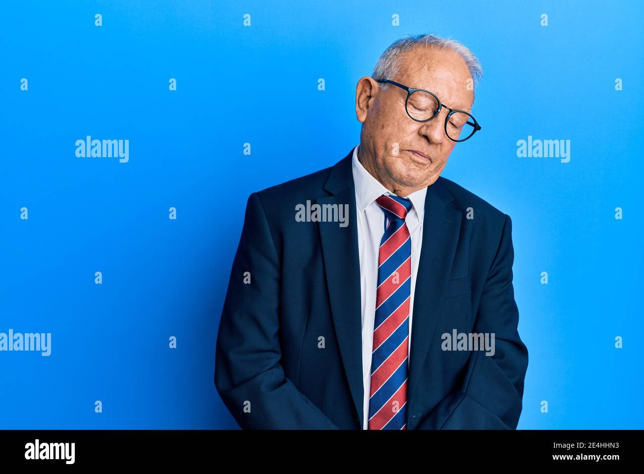 Senior caucasian man wearing business suit and tie looking sleepy and ...