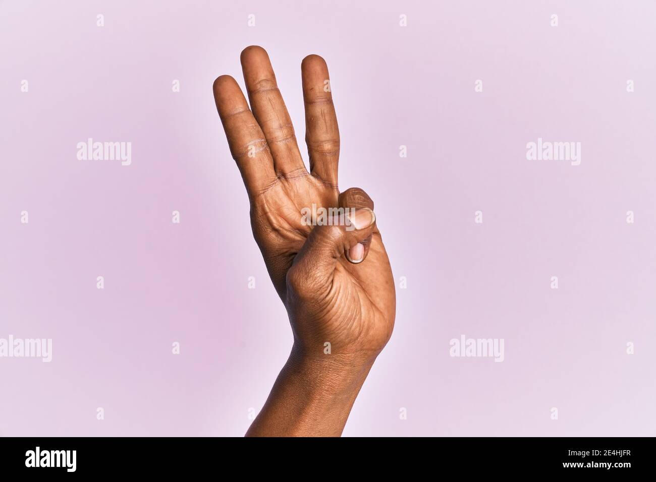 Arm and hand of black middle age woman over pink isolated background ...