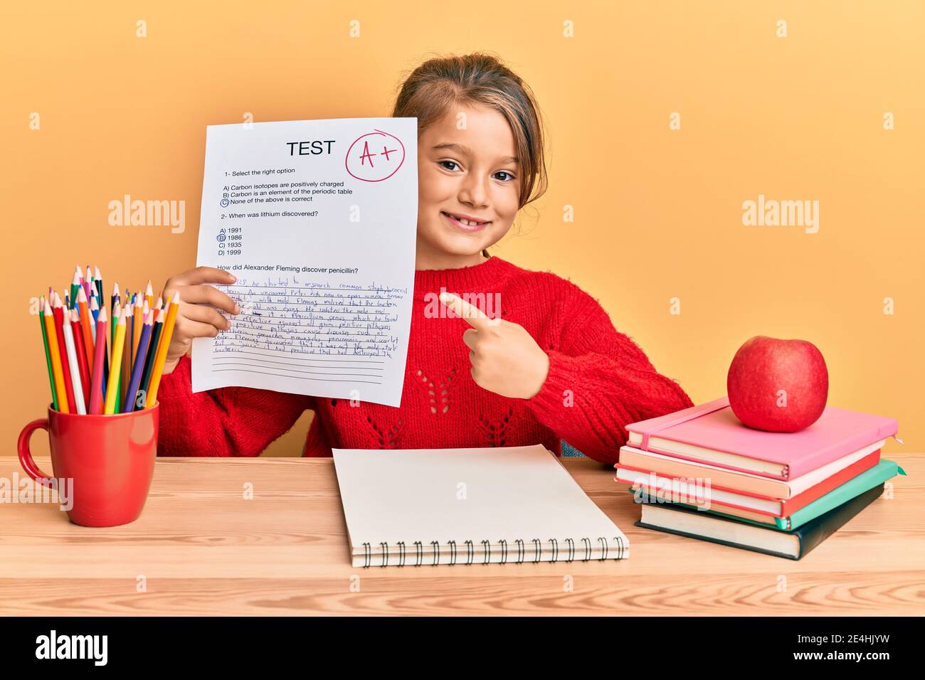 Little beautiful girl showing a passed exam smiling happy pointing with ...
