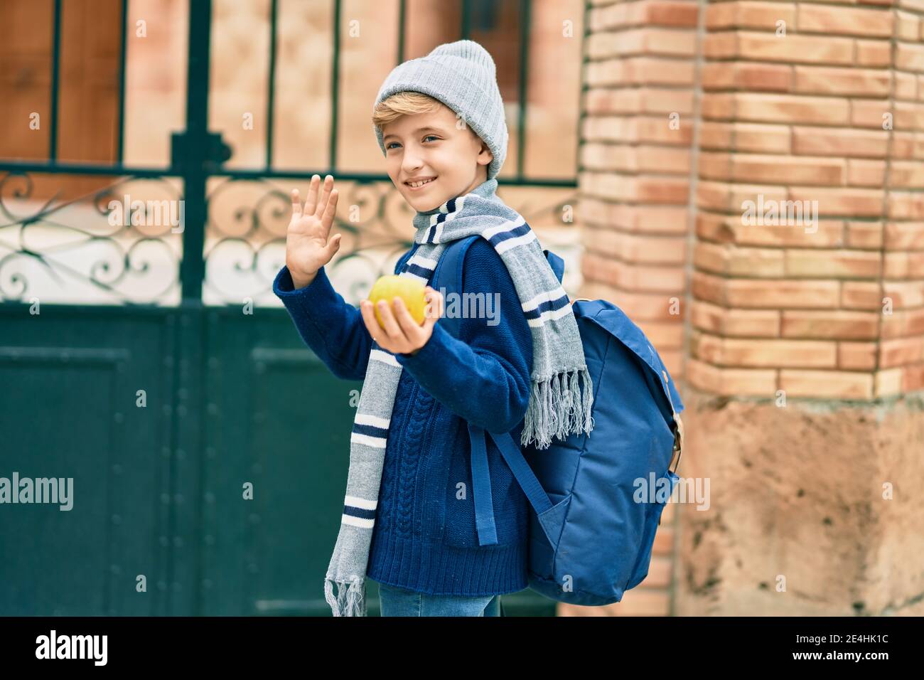 Adorable blond student kid saying goodbye with hand getting in the ...