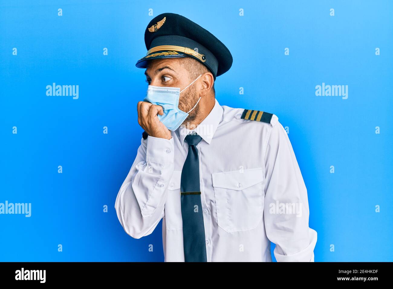 Handsome man with beard wearing airplane pilot uniform wearing safety ...