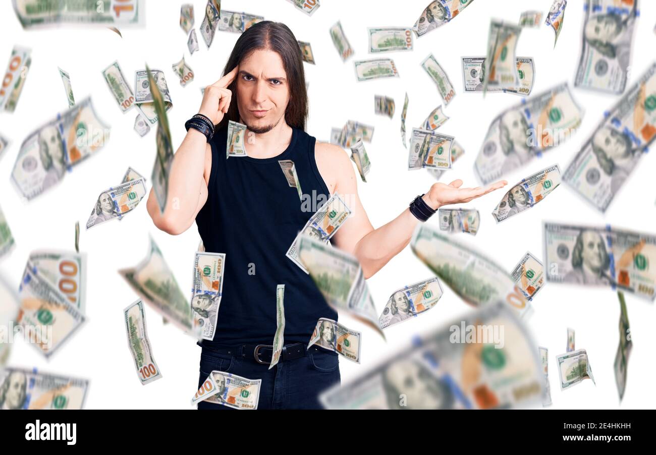 Young adult man with long hair wearing goth style with black clothes ...