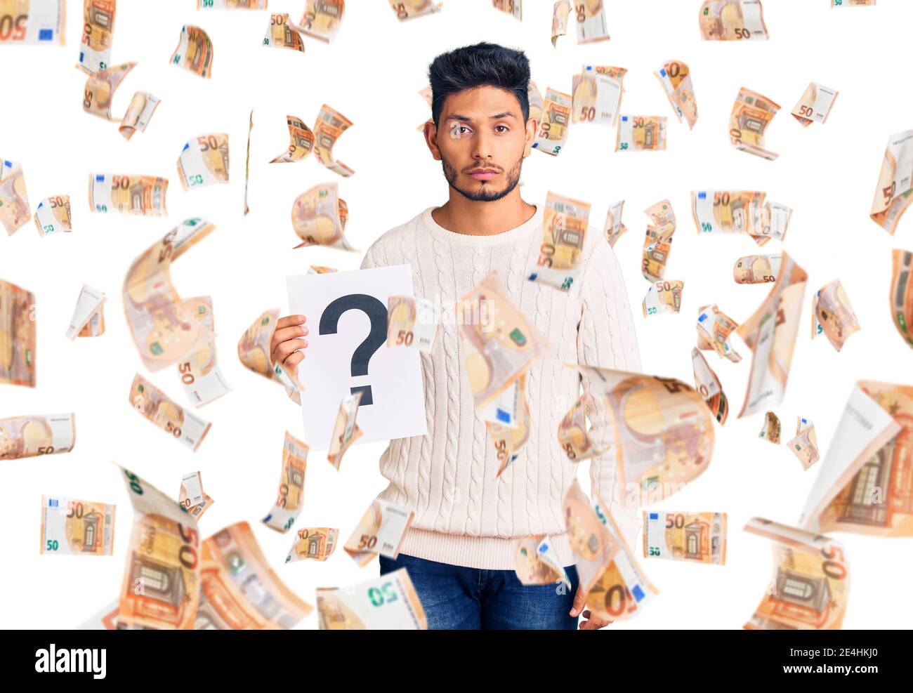 Handsome latin american young man holding question mark thinking ...