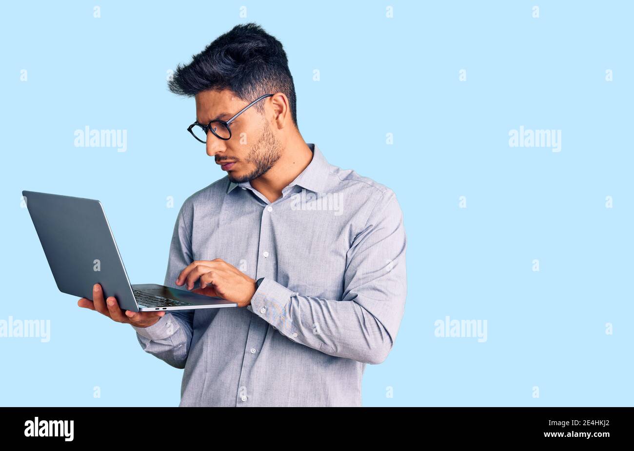 Handsome latin american young man working using computer laptop ...