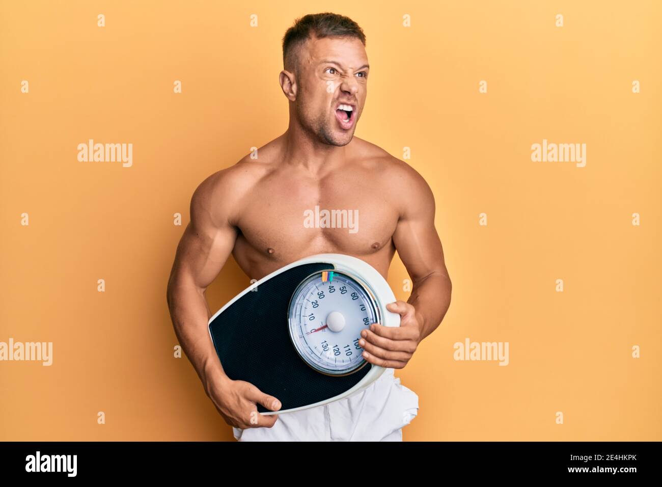 Handsome muscle man holding weight machine to balance weight loss angry ...