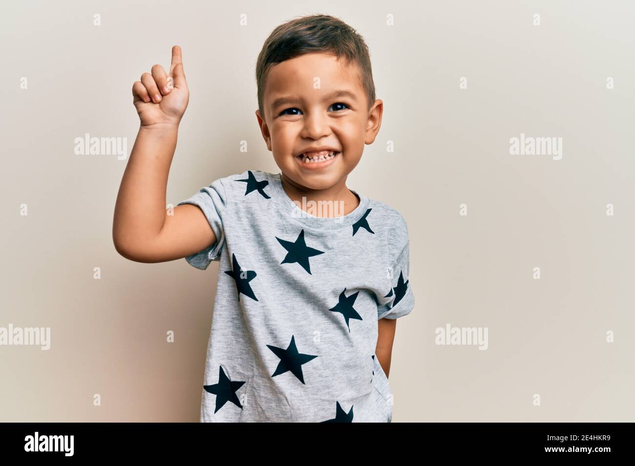 Adorable latin toddler wearing casual clothes smiling with an idea or ...