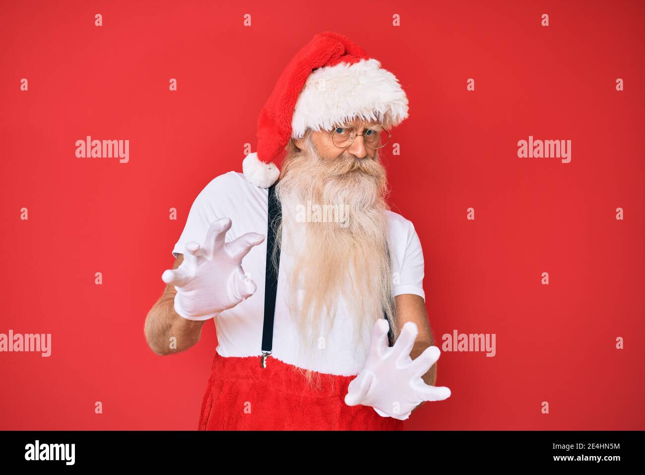 Old senior man with grey hair and long beard wearing white t-shirt and ...