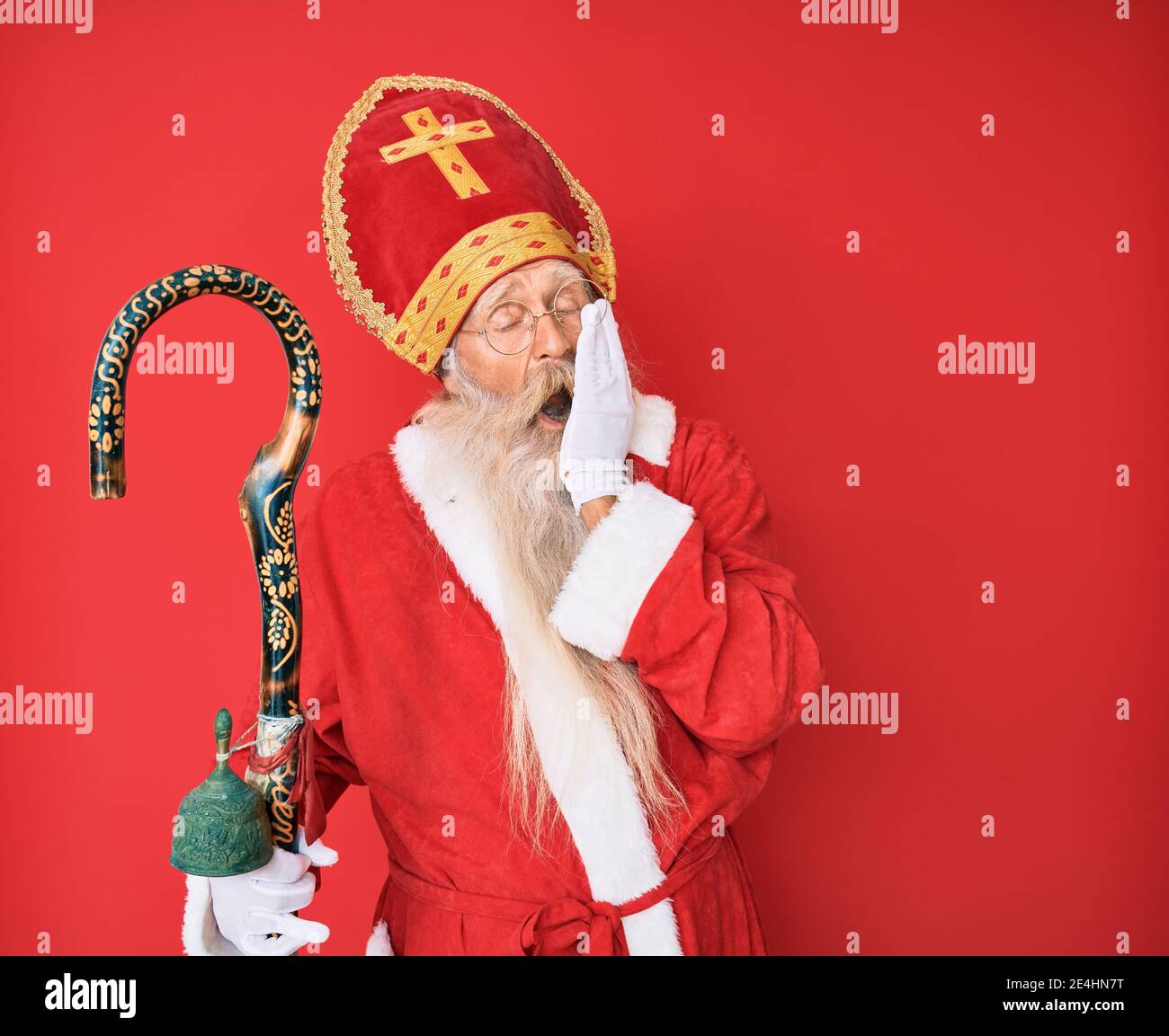 Old senior man with grey hair and long beard wearing traditional saint ...