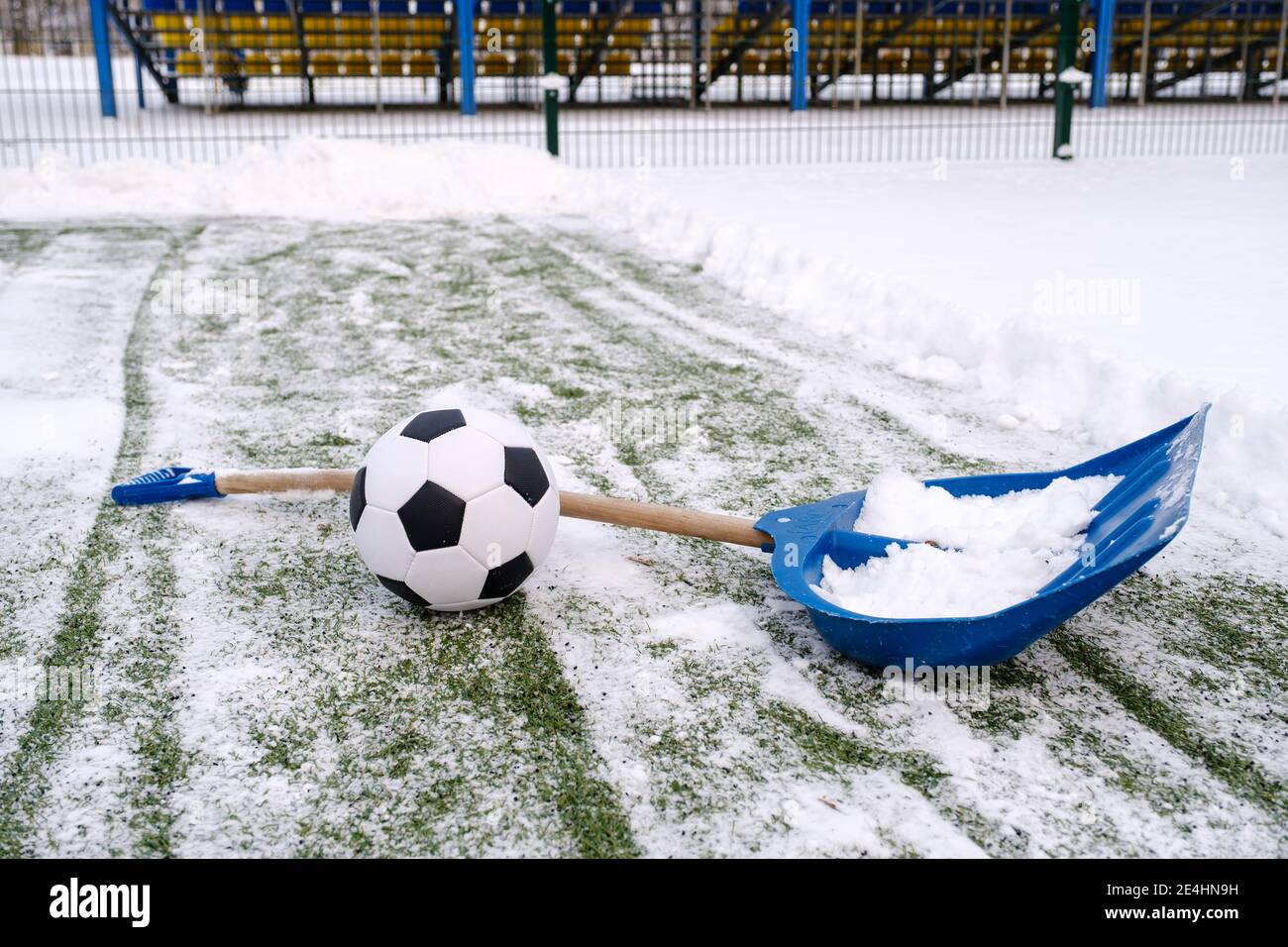 Shovel, snow-covered football field and classic soccer ball Stock Photo ...