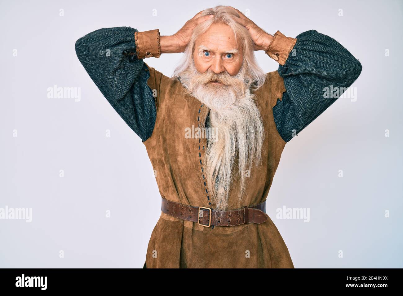 Old senior man with grey hair and long beard wearing viking traditional ...