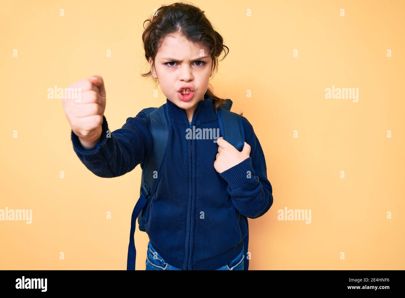 Cute hispanic child holding student backpack annoyed and frustrated ...