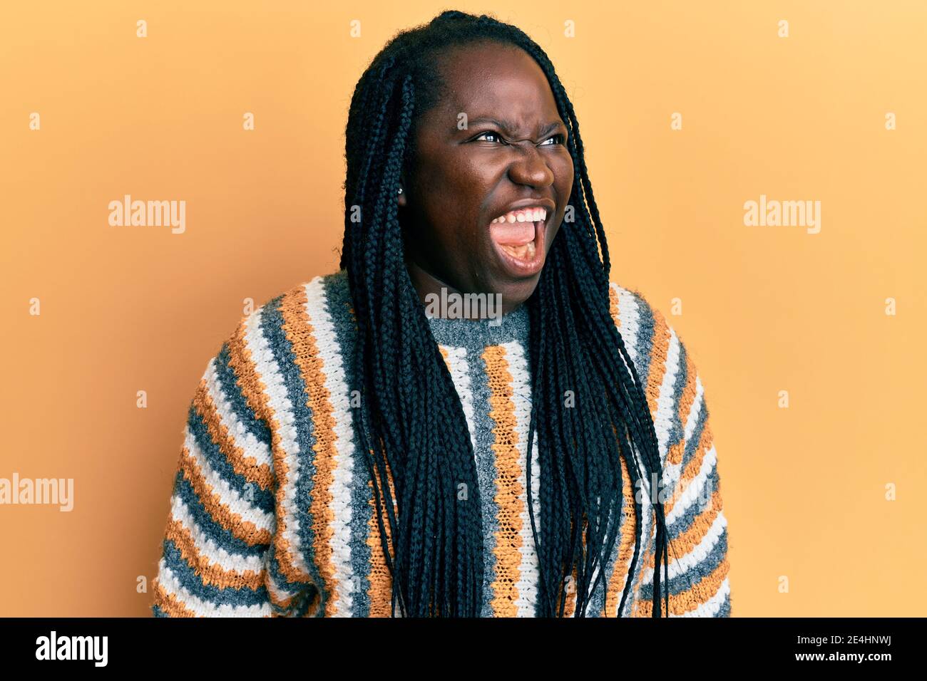 Young black woman with braids wearing casual winter sweater angry and ...