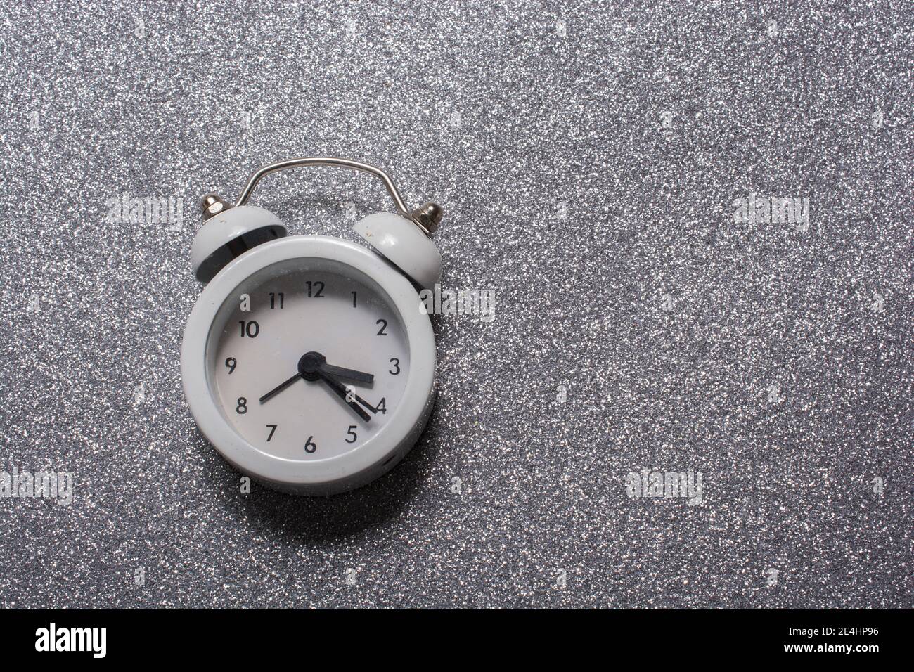 A top view of a white alarm clock on a concrete surface Stock Photo - Alamy