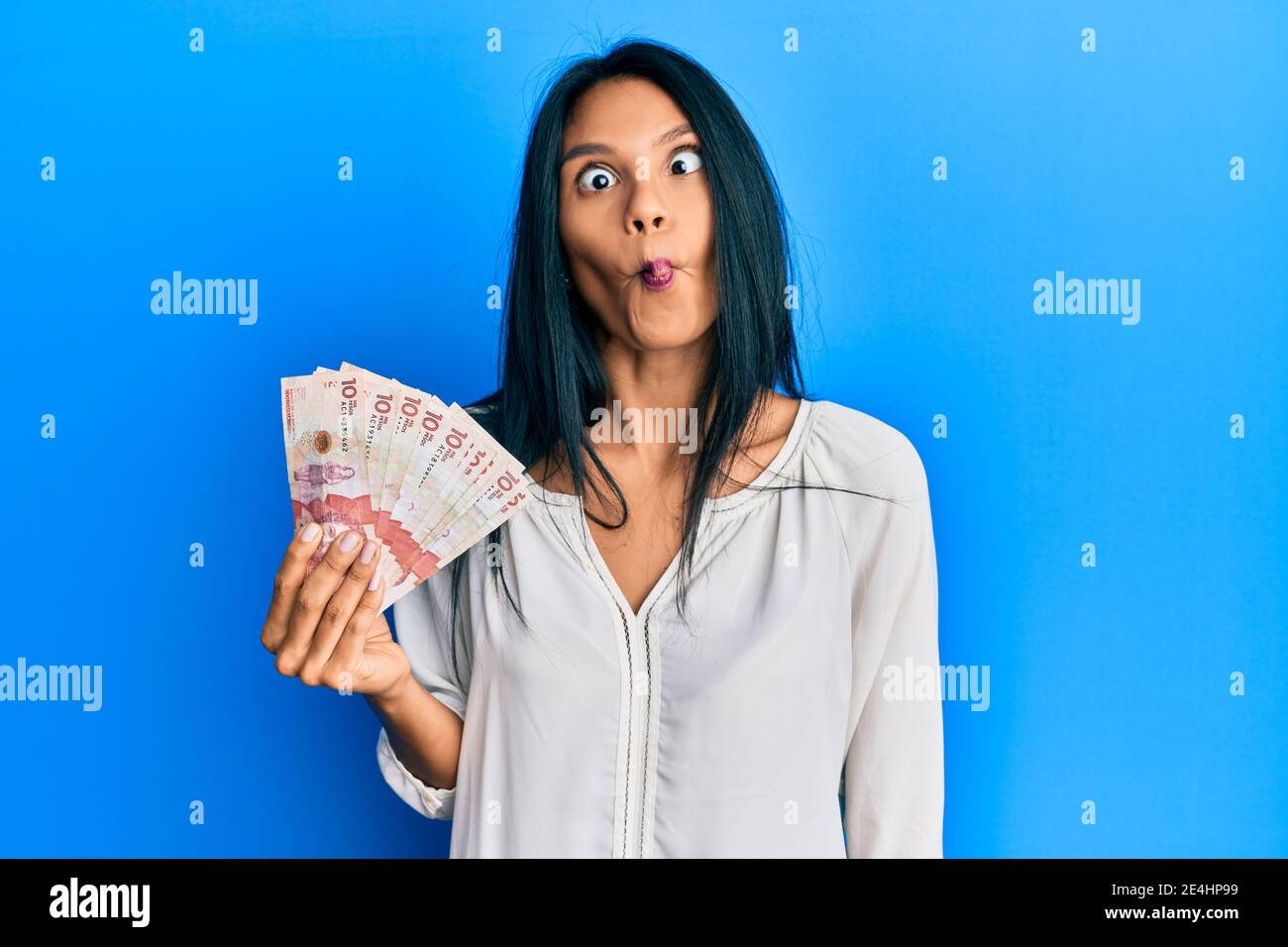 Young african american woman holding 10 colombian pesos banknotes ...