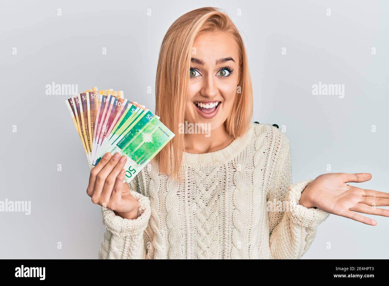 Beautiful caucasian woman holding norwegian krone banknotes celebrating ...