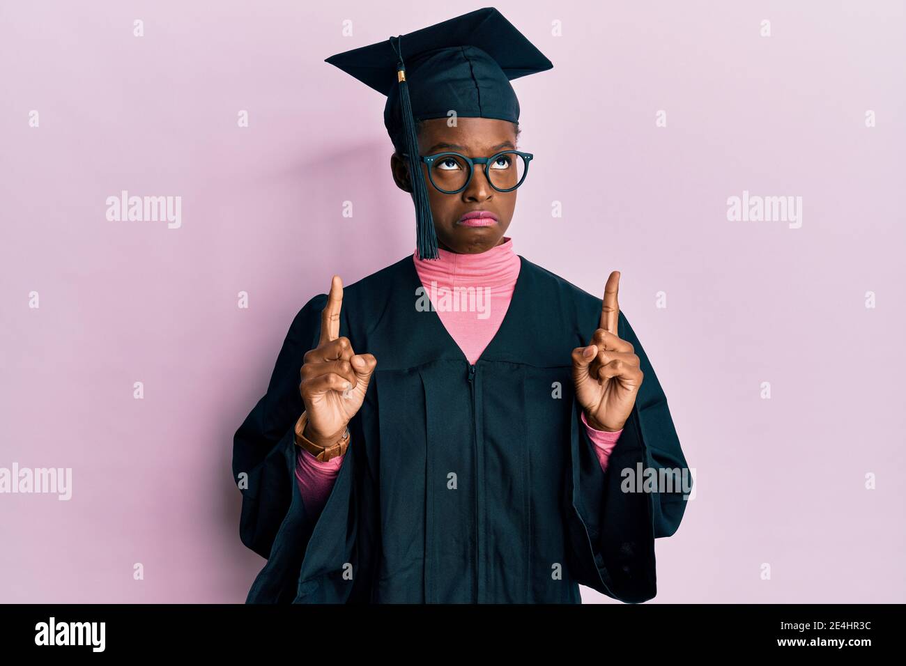 Young african american girl wearing graduation cap and ceremony robe ...
