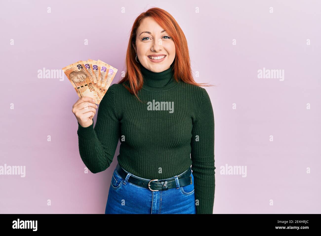 Beautiful redhead woman holding south african 20 rand banknotes looking ...