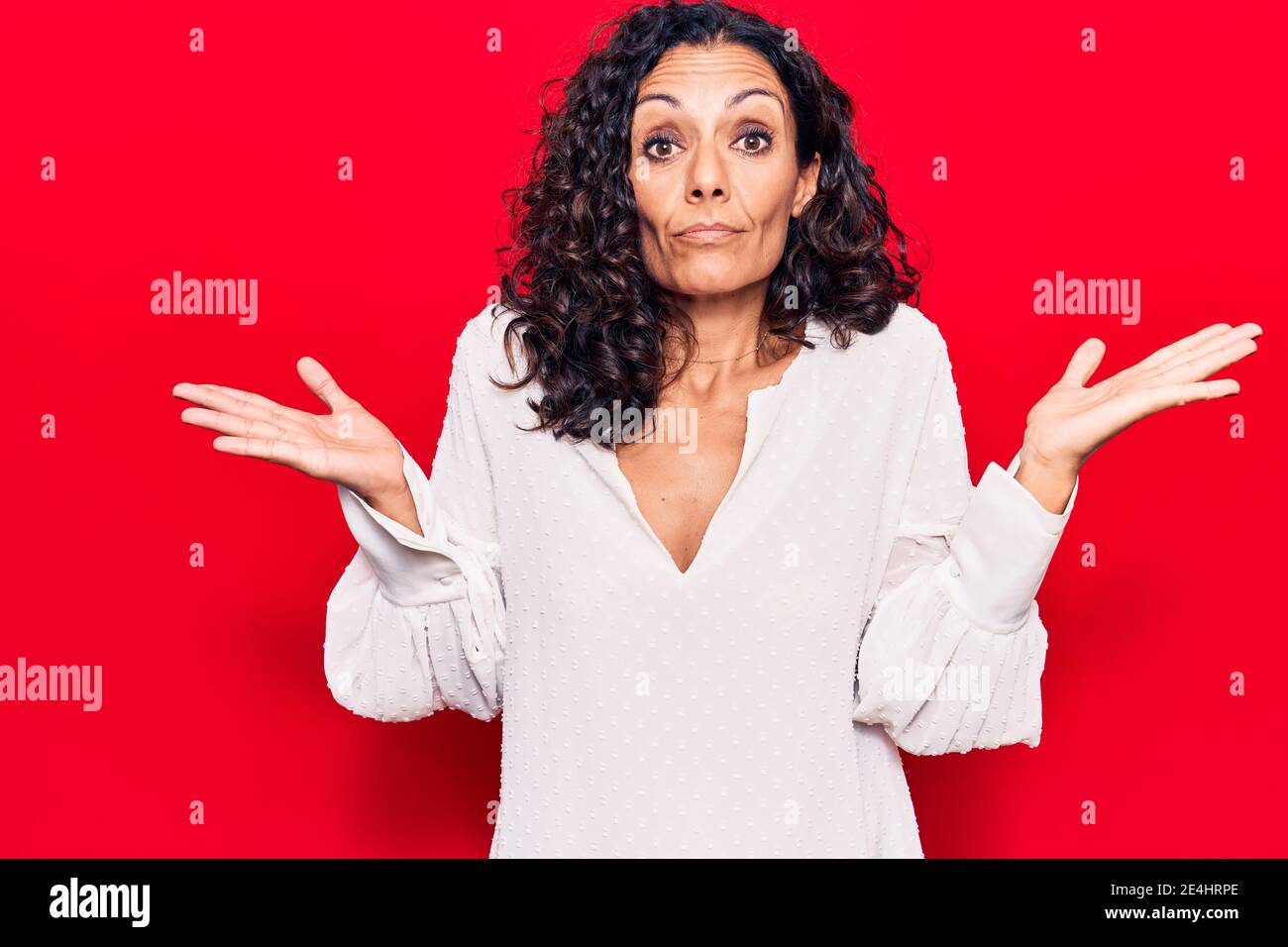 Middle age beautiful woman wearing casual shirt clueless and confused ...
