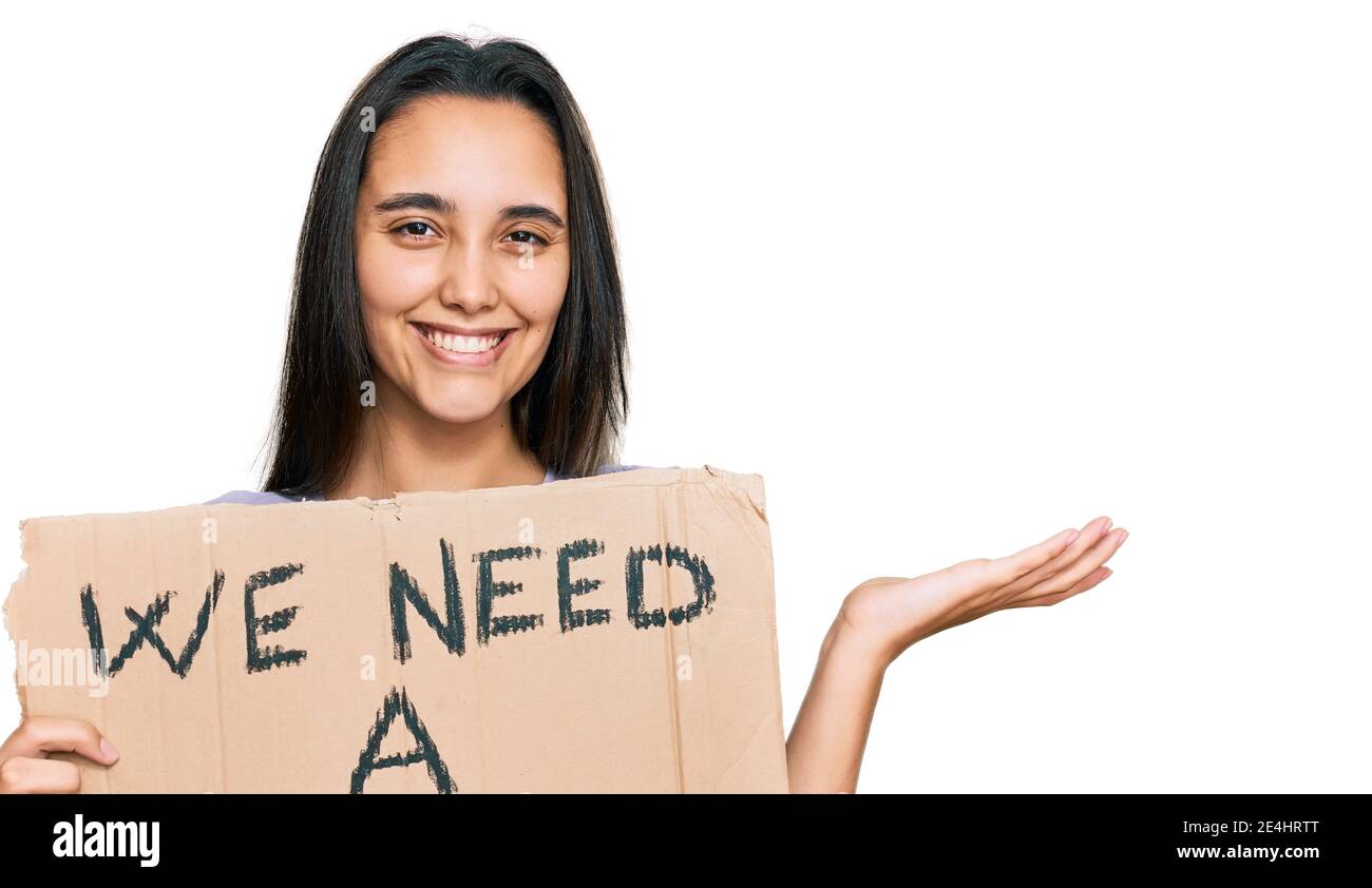 Young hispanic woman holding we need a change banner celebrating ...