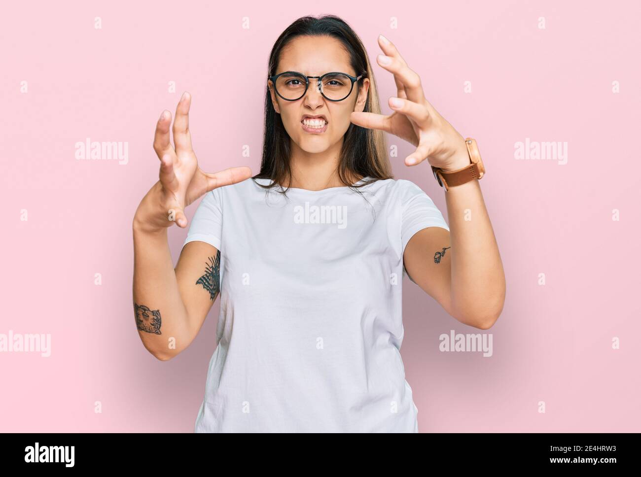 Young hispanic woman wearing casual white t shirt shouting frustrated ...