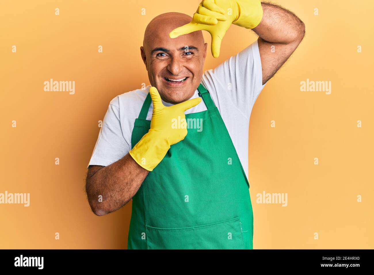 Mature middle east man wearing cleaner apron and gloves smiling making ...
