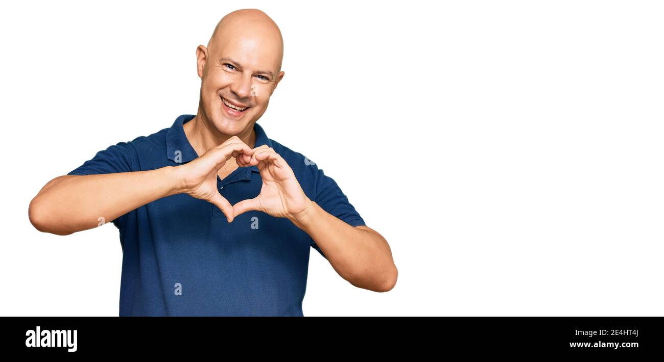 Middle age bald man wearing casual clothes smiling in love doing heart ...