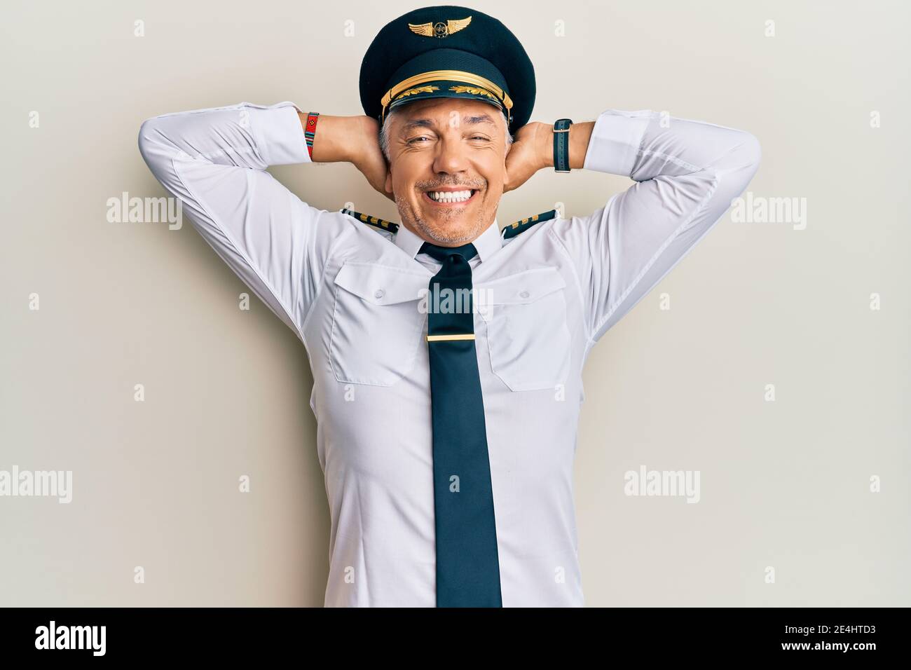 Handsome middle age mature man wearing airplane pilot uniform relaxing ...