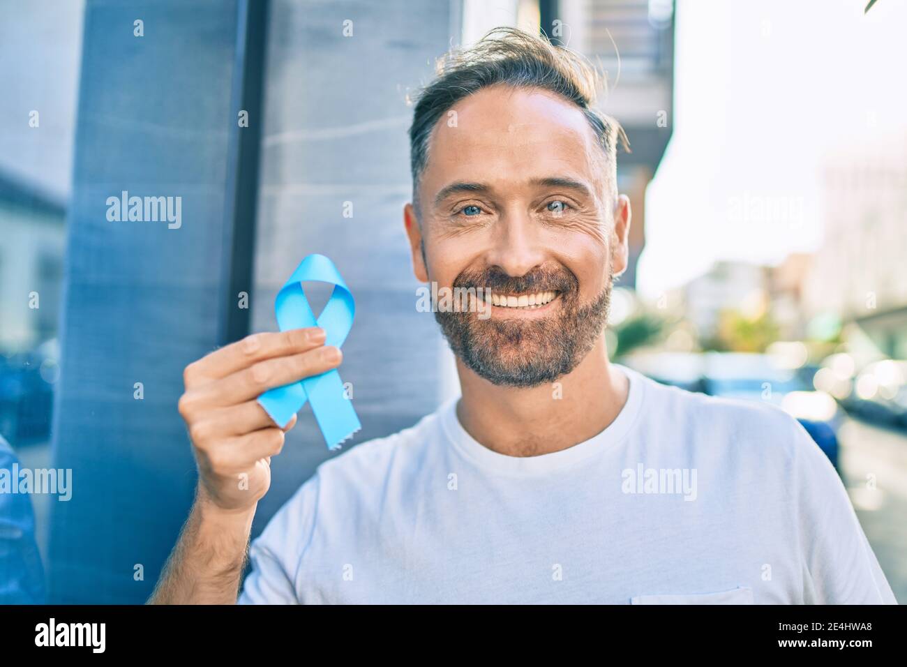 Middle age handsome man smiling happy holding blue prostate cancer ...