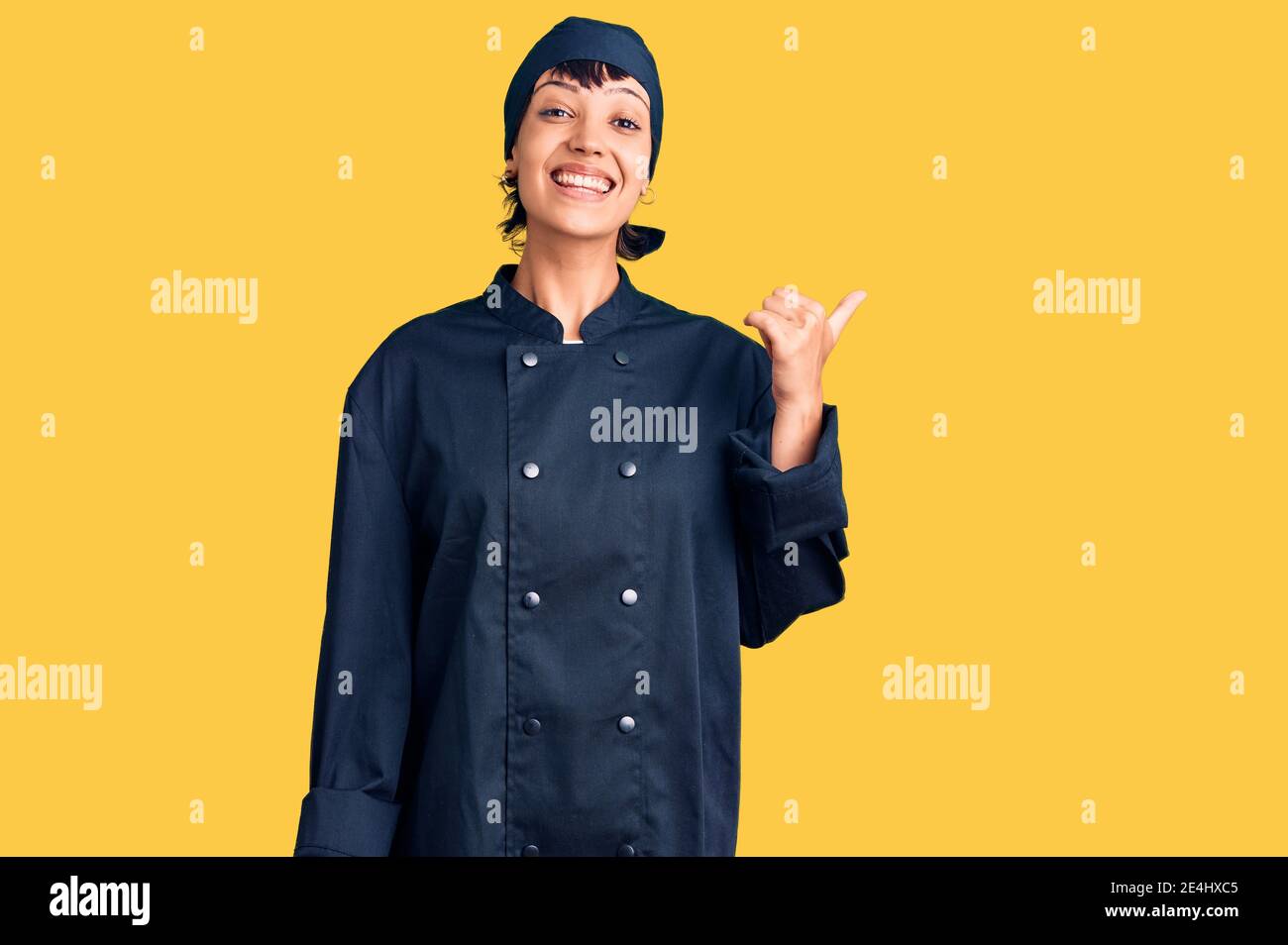 Young brunette woman with short hair wearing professional cook uniform ...