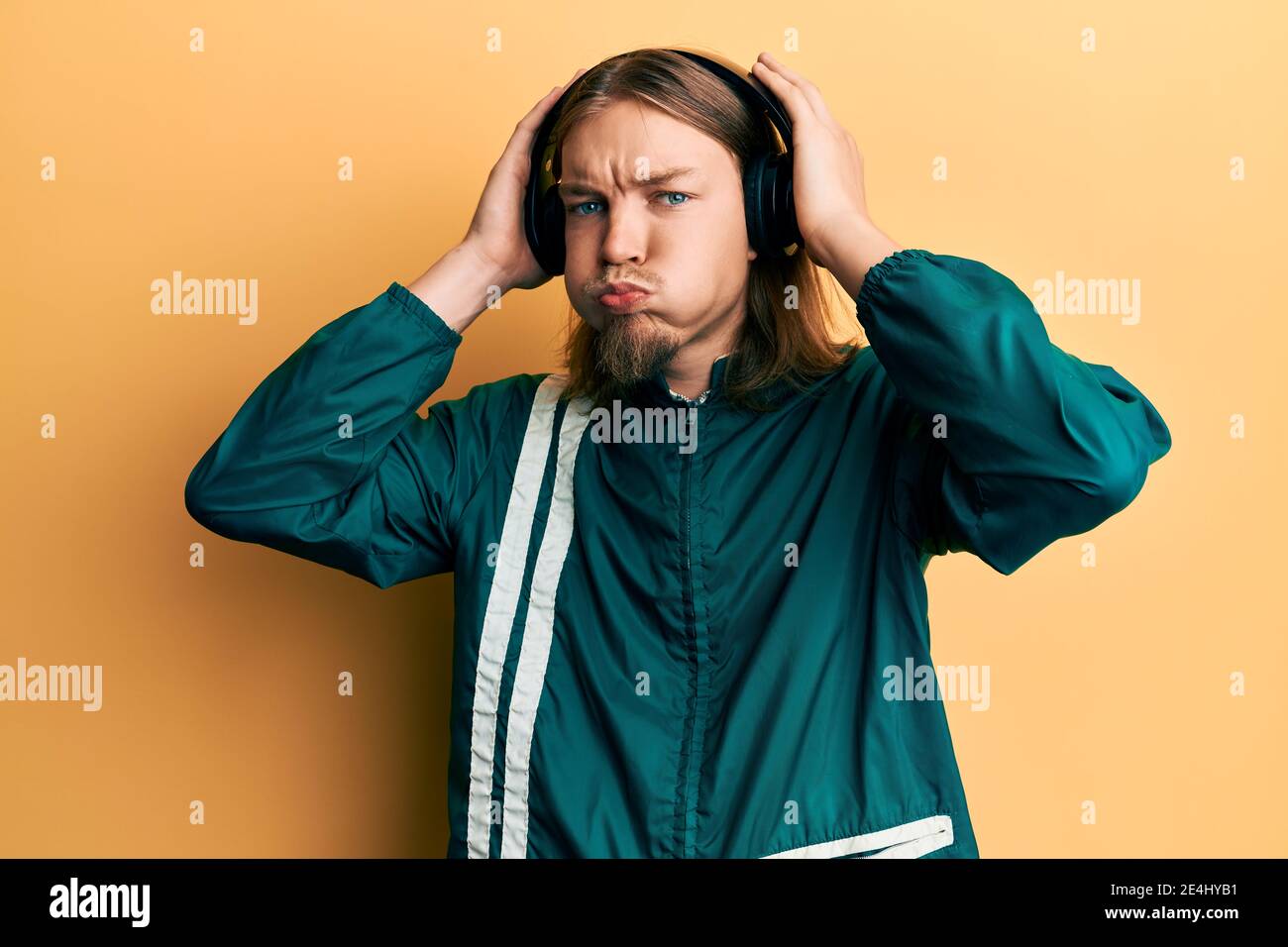 Handsome caucasian man with long hair wearing gym clothes and using ...