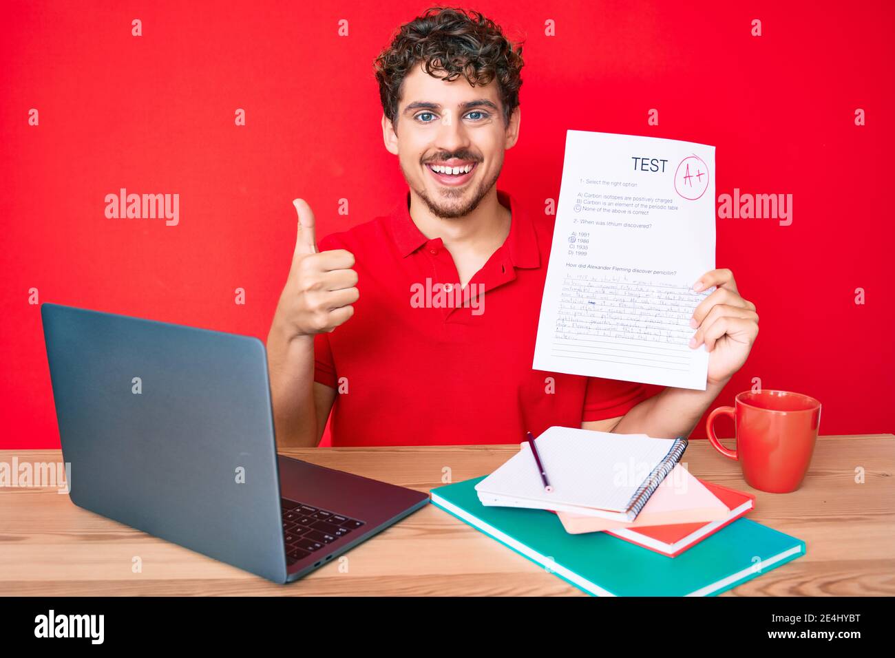 Young caucasian man with curly hair showing a passed exam sitting on ...