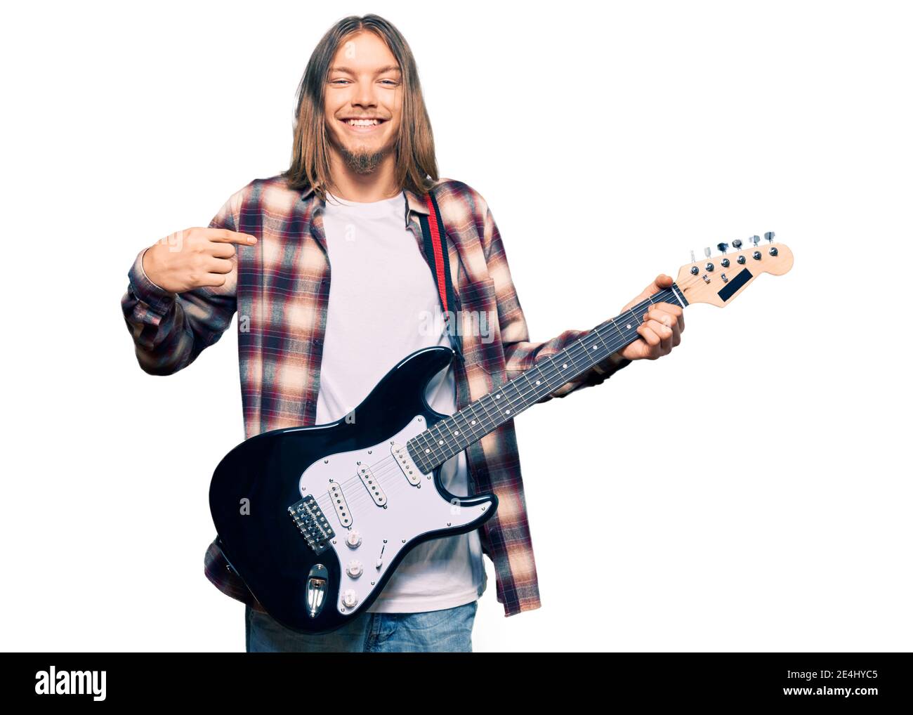 Handsome caucasian man with long hair playing electric guitar pointing ...