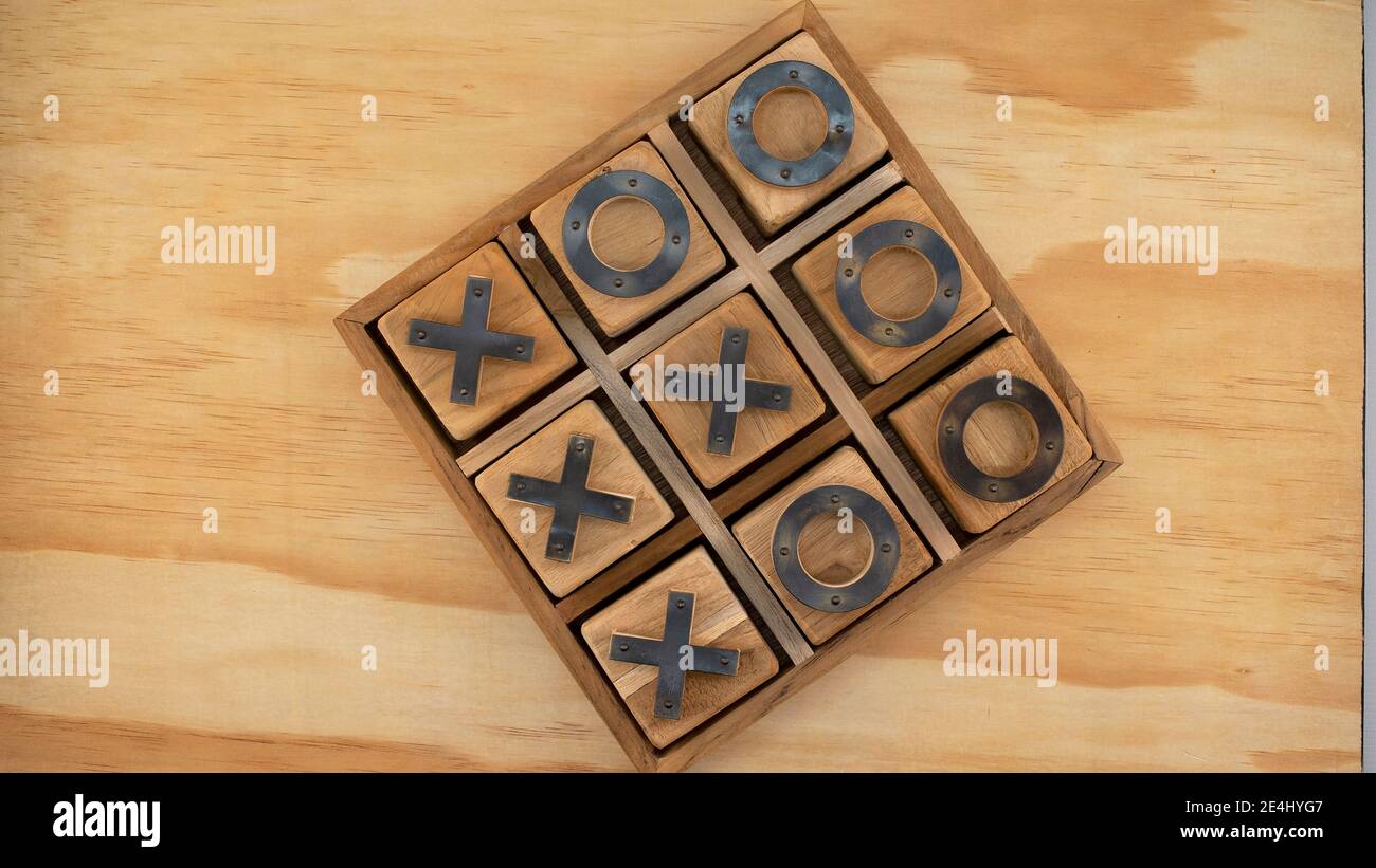 Board game of noughts and crosses on a timber background Stock Photo ...