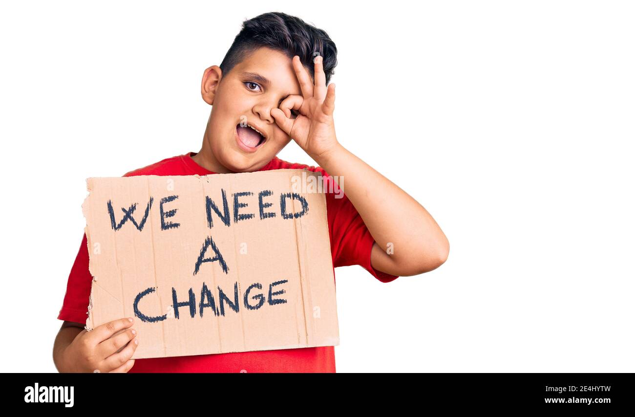 Little boy kid holding we need a change banner smiling happy doing ok ...