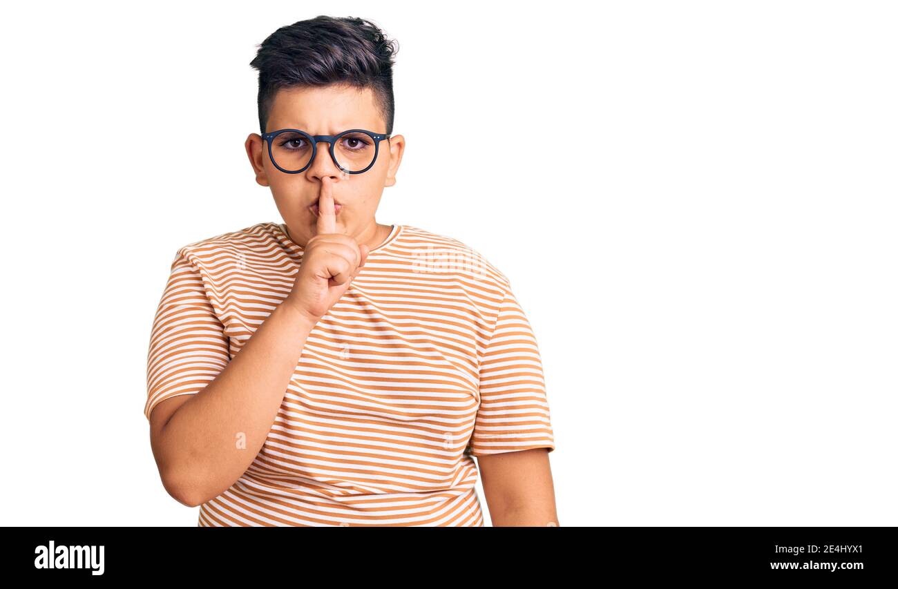 Little boy kid wearing casual clothes and glasses asking to be quiet ...