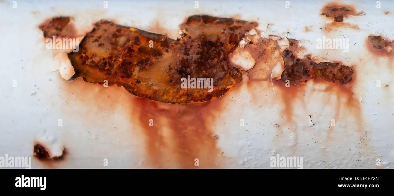 Large patch of rust is visible through white paint that is peeled off ...