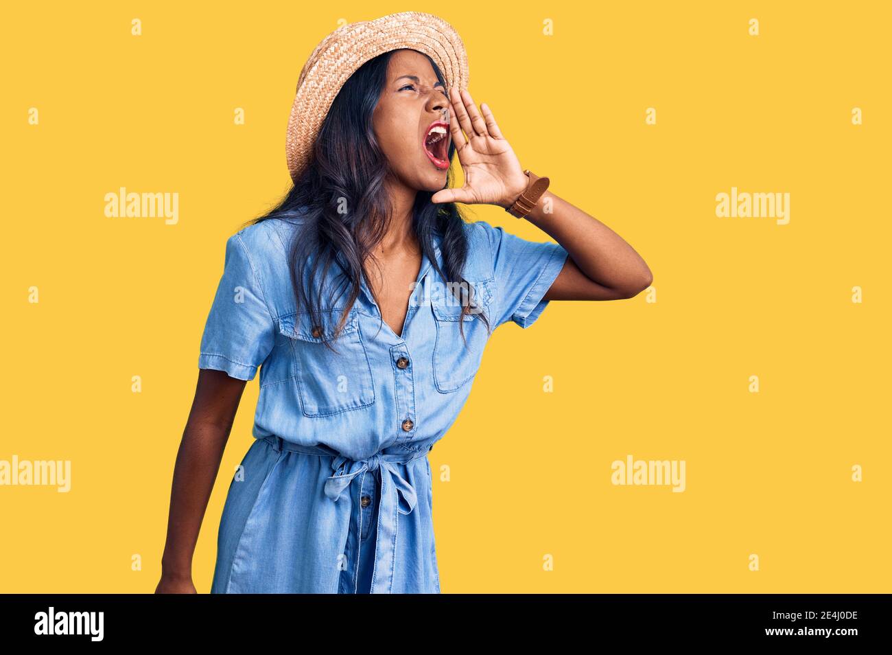 Young indian girl wearing summer hat shouting and screaming loud to ...