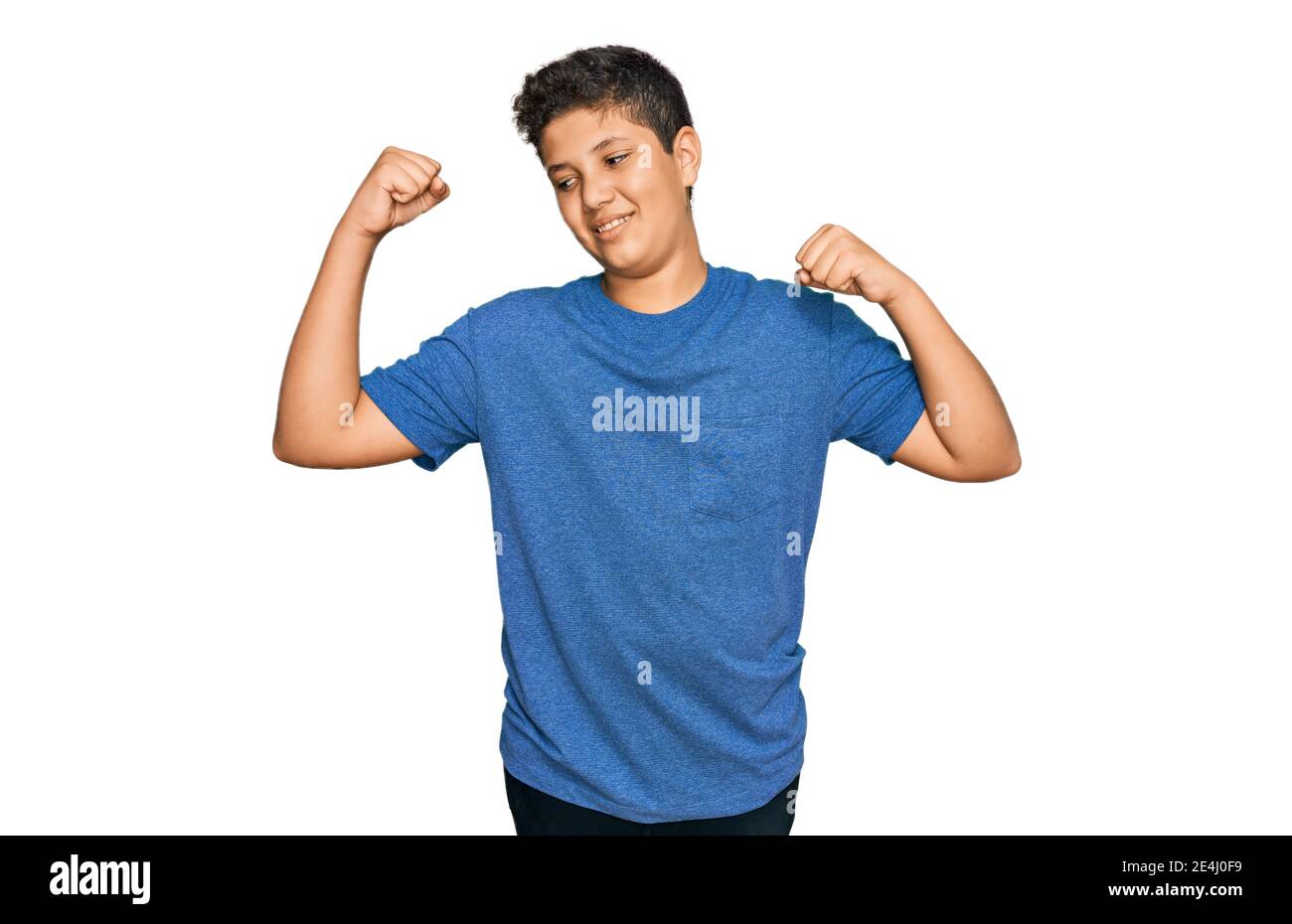 Teenager hispanic boy wearing casual clothes showing arms muscles ...