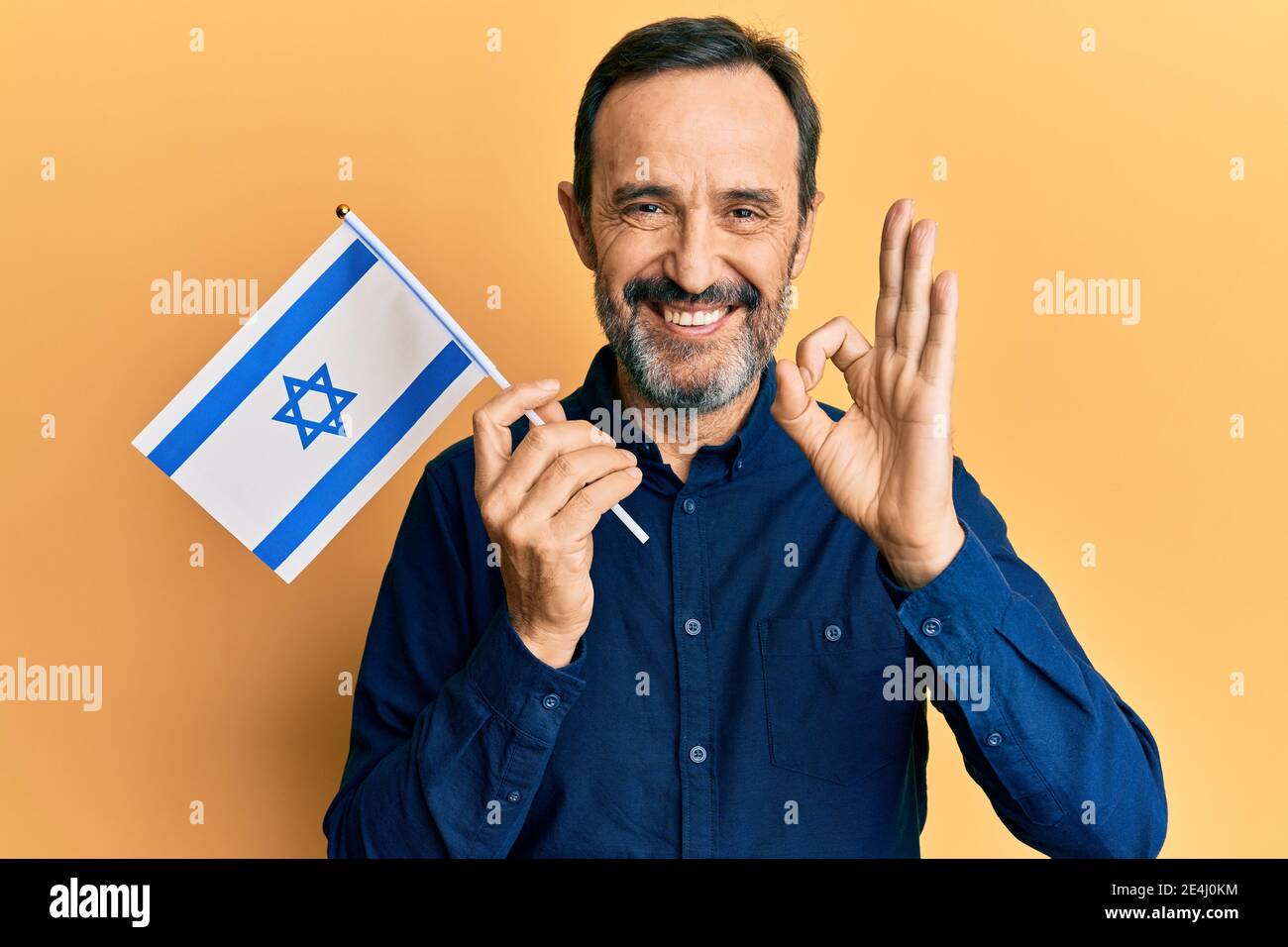 Middle age hispanic man holding israel flag doing ok sign with fingers ...