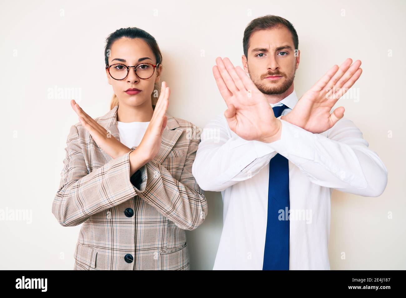 Beautiful couple wearing business clothes rejection expression crossing ...