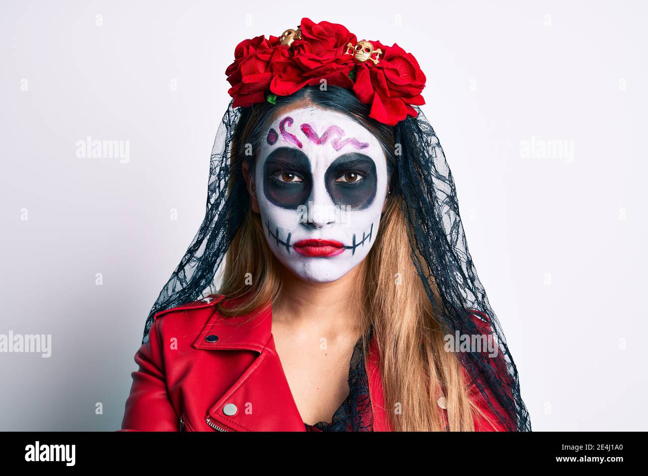 Woman wearing day of the dead costume over white skeptic and nervous ...