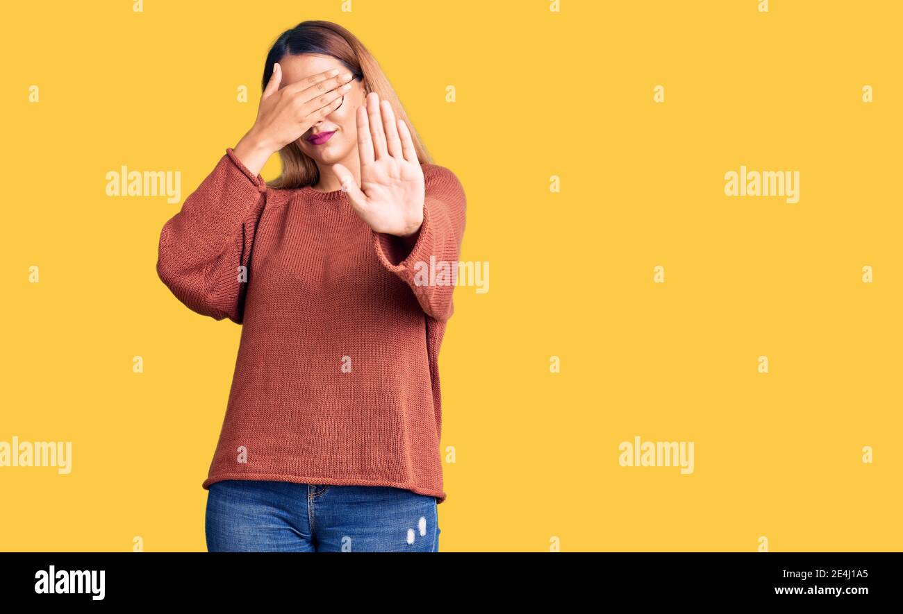 Beautiful young woman wearing casual clothes and glasses covering eyes ...