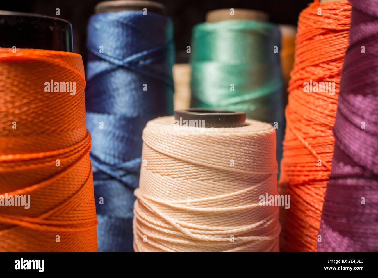 Multiple colored spools and line cones. Blue, orange purple, green ...