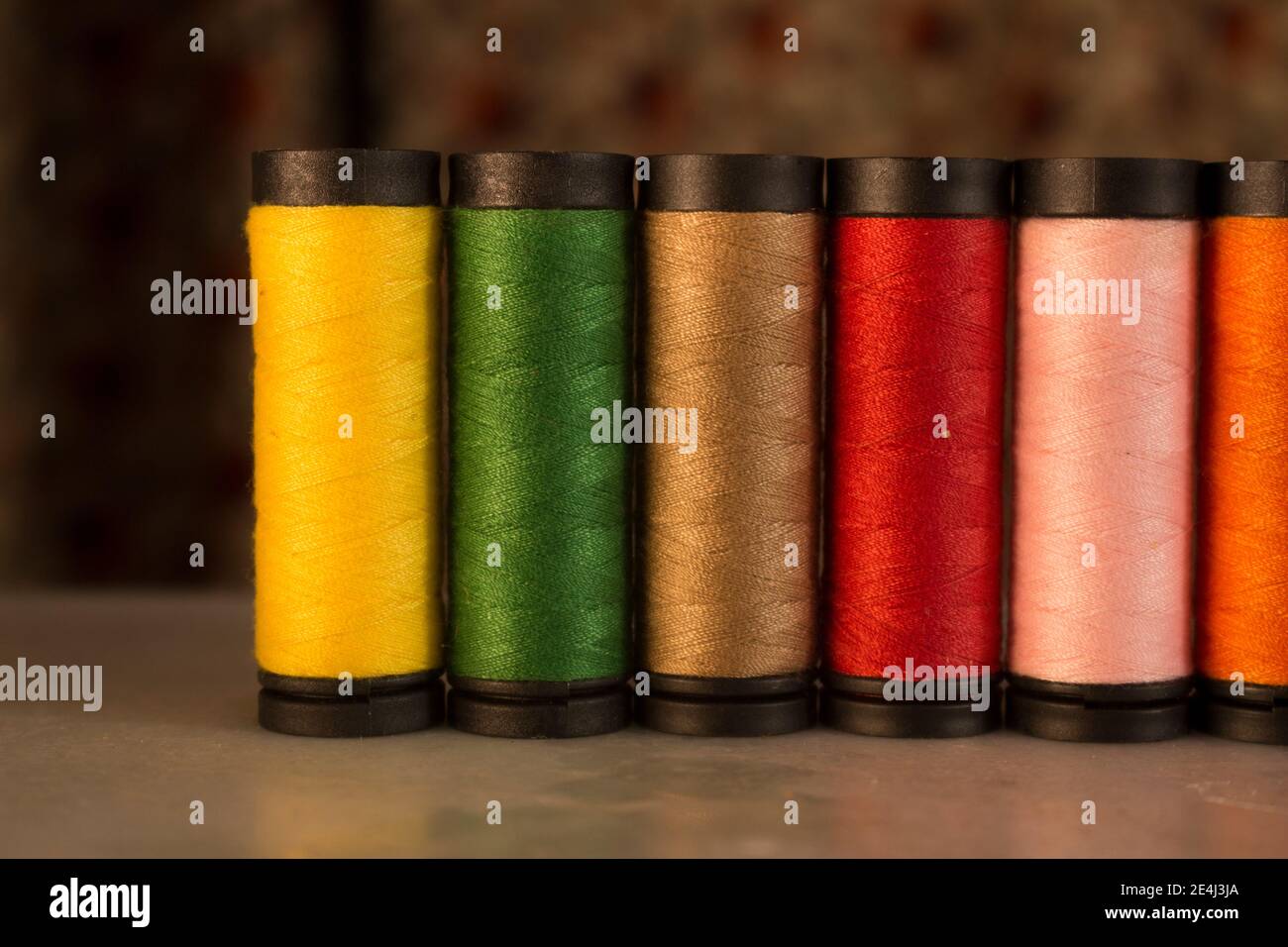 Multicolored thread spools lined as a row Stock Photo - Alamy